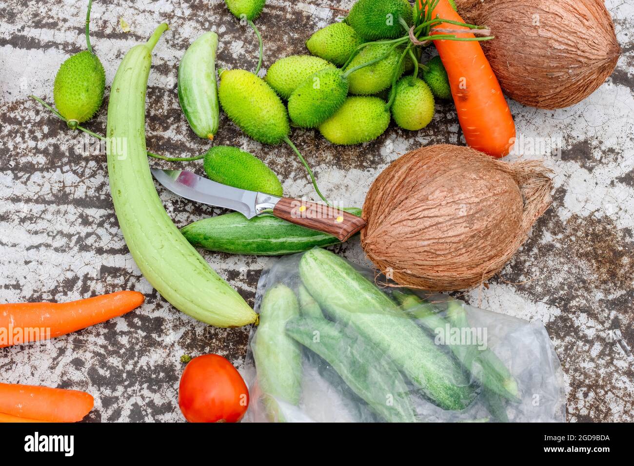 Scattered vegetables and fruits with a knife on a crack textured floor ...