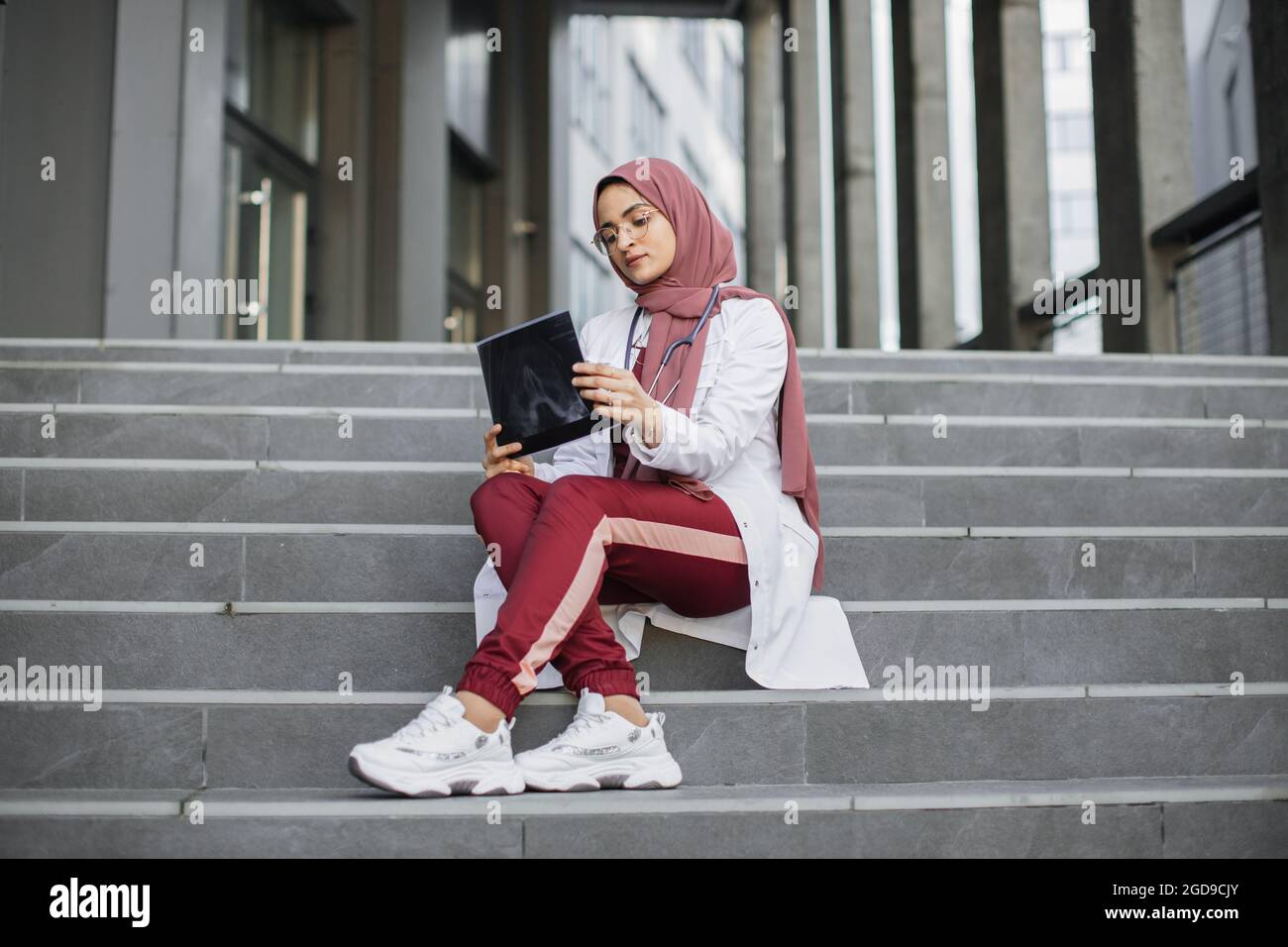 Female medical student studying patient's xray outdoors. Pretty ...