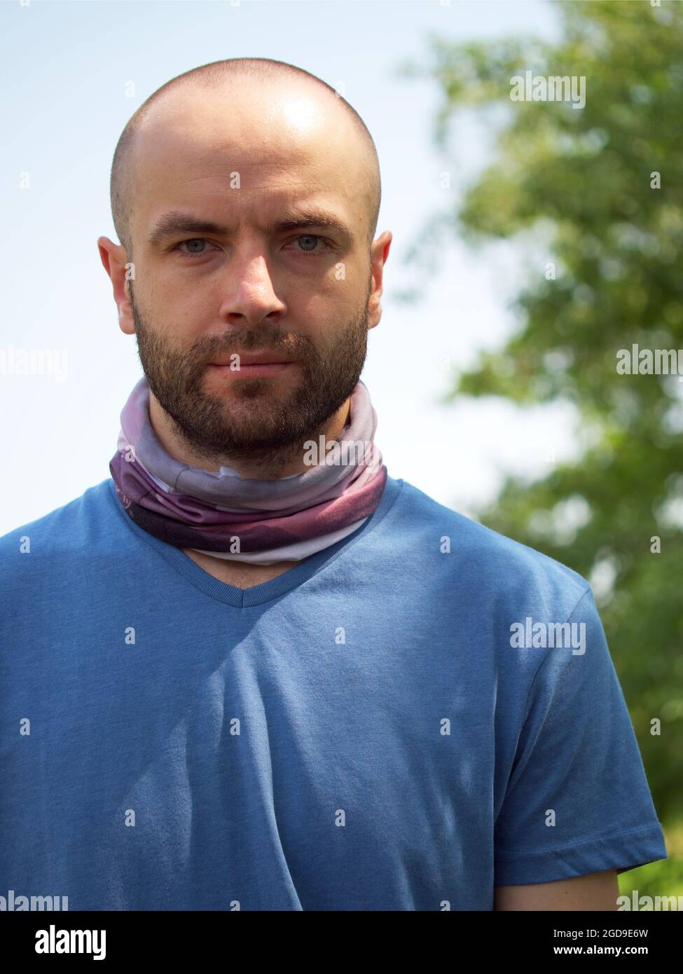 Bust portrait of a white-skinned man. Bald man with a beard and a buff ...