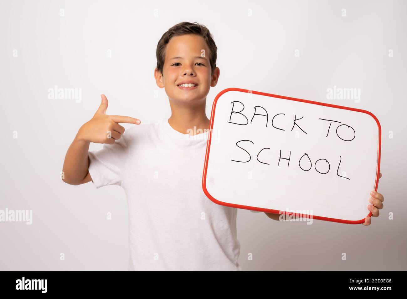 Smiling male student holding signboard isolated over white background ...