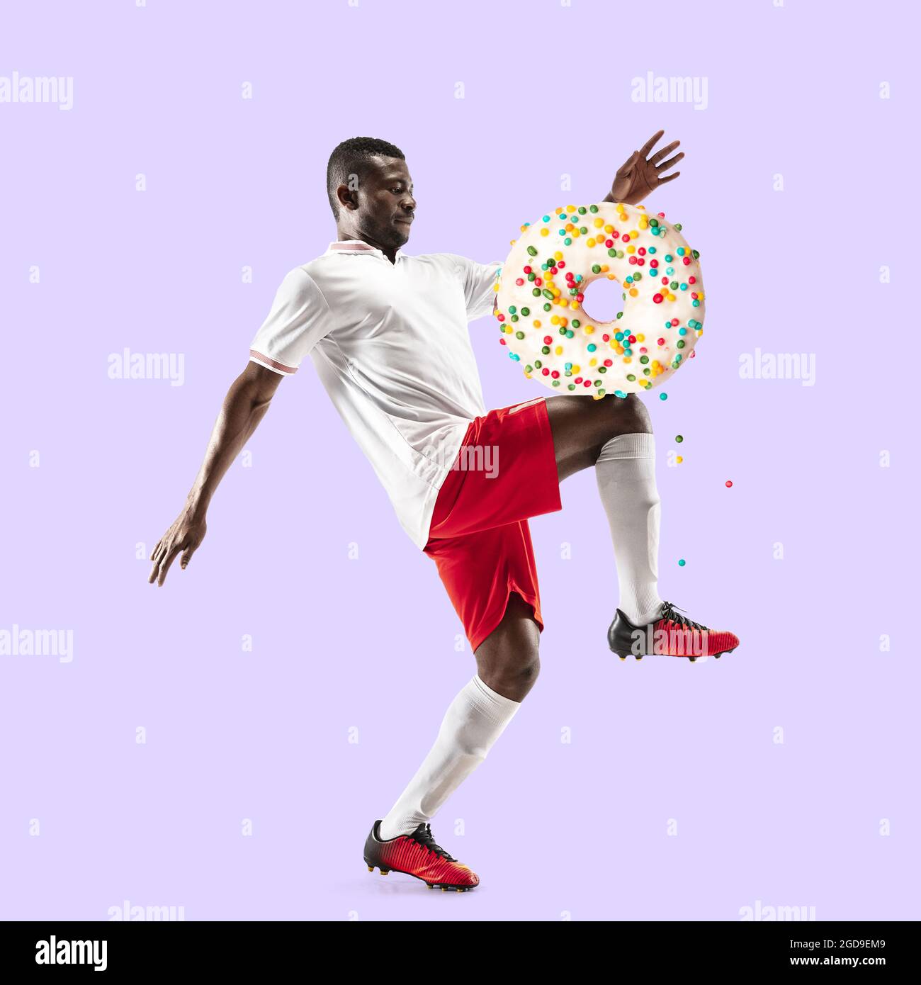 Fit young man fighting off bad food on color background. Male soccer ...
