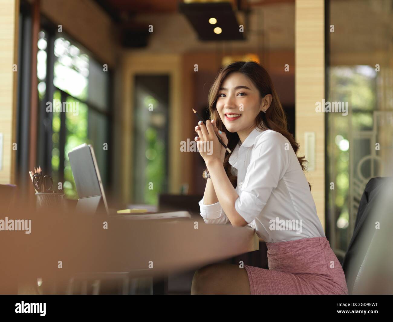 Beautiful millennial businesswoman sitting and daydreaming her work ...