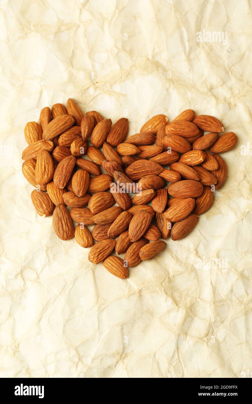 Almonds on old paper background Stock Photo - Alamy