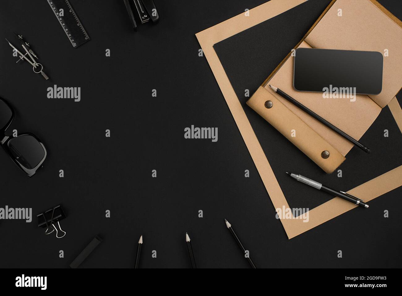 Office desktop with various black objects on background Stock Photo - Alamy