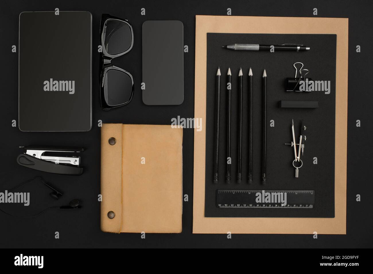 Office desktop with various black objects on background Stock Photo - Alamy