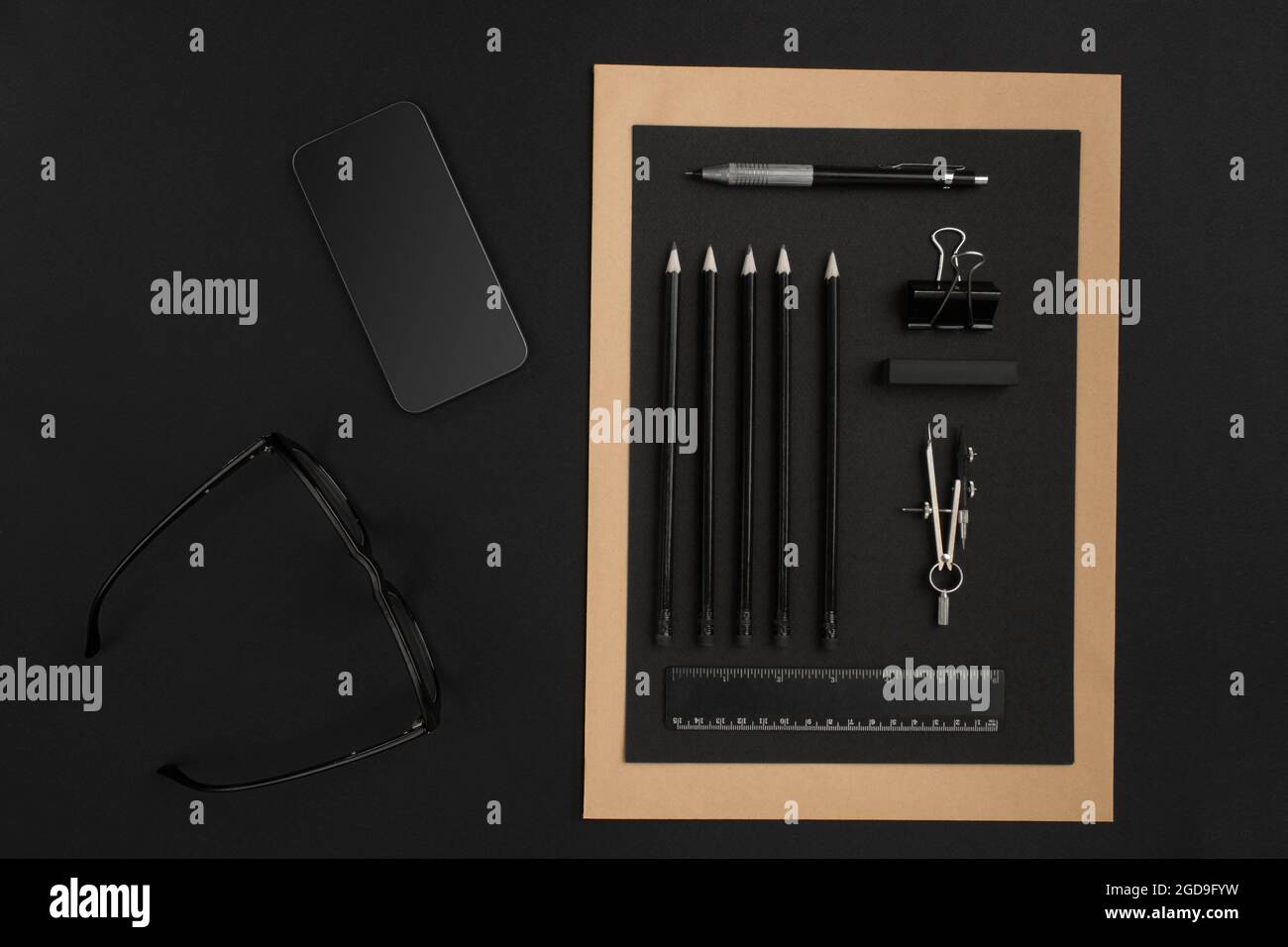 Office desktop with various black objects on background Stock Photo - Alamy