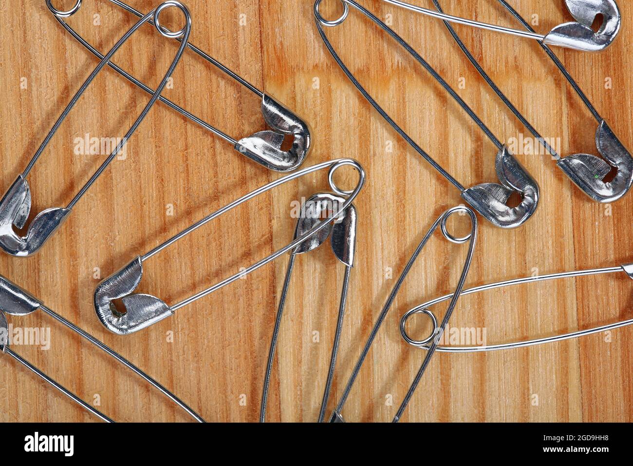 Safety pins on wooden background Stock Photo - Alamy