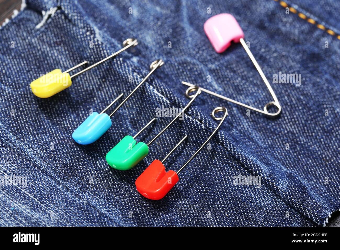 Safety pins on fabric background Stock Photo - Alamy