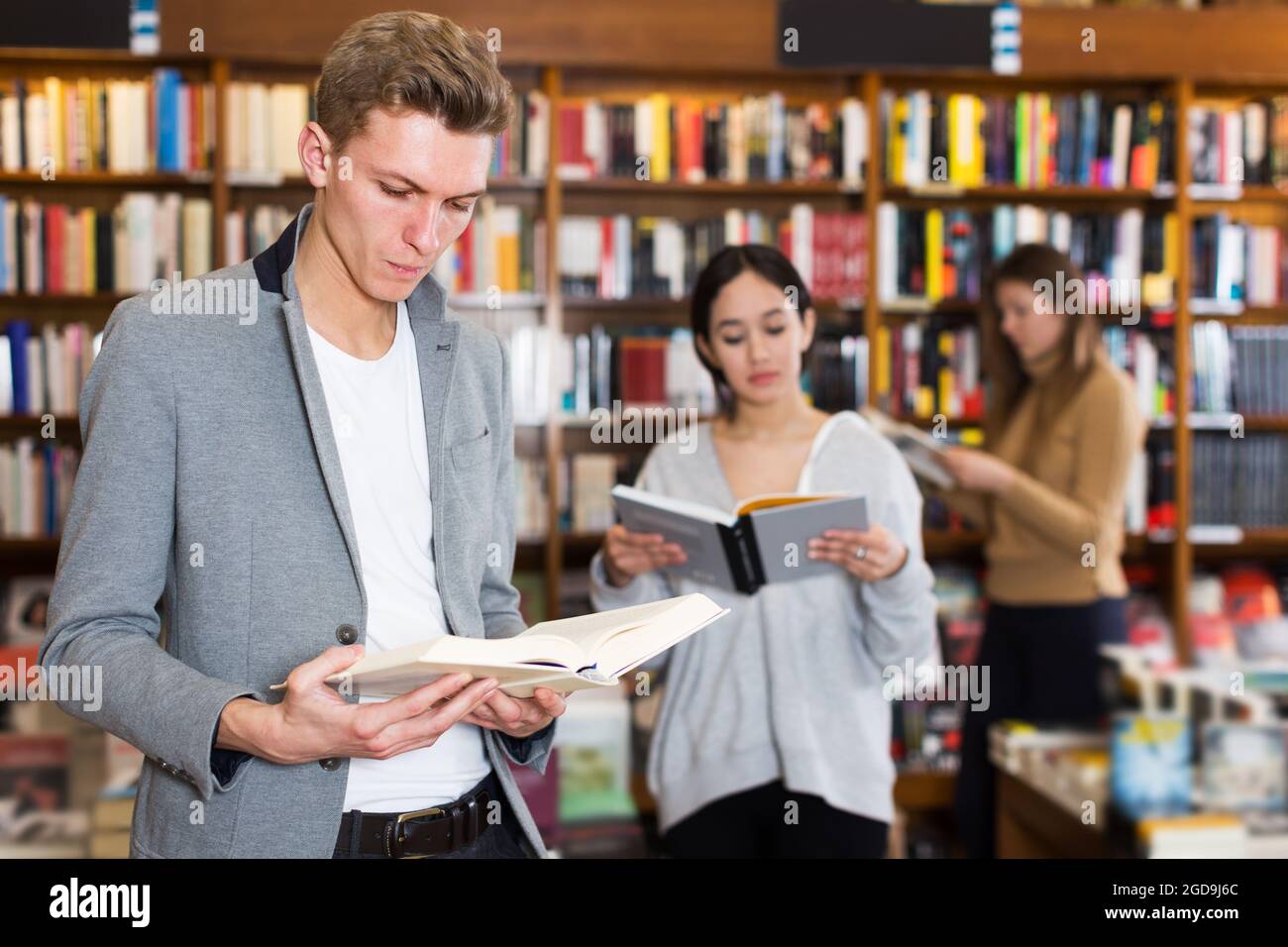 Student browsing textbooks in library Stock Photo - Alamy