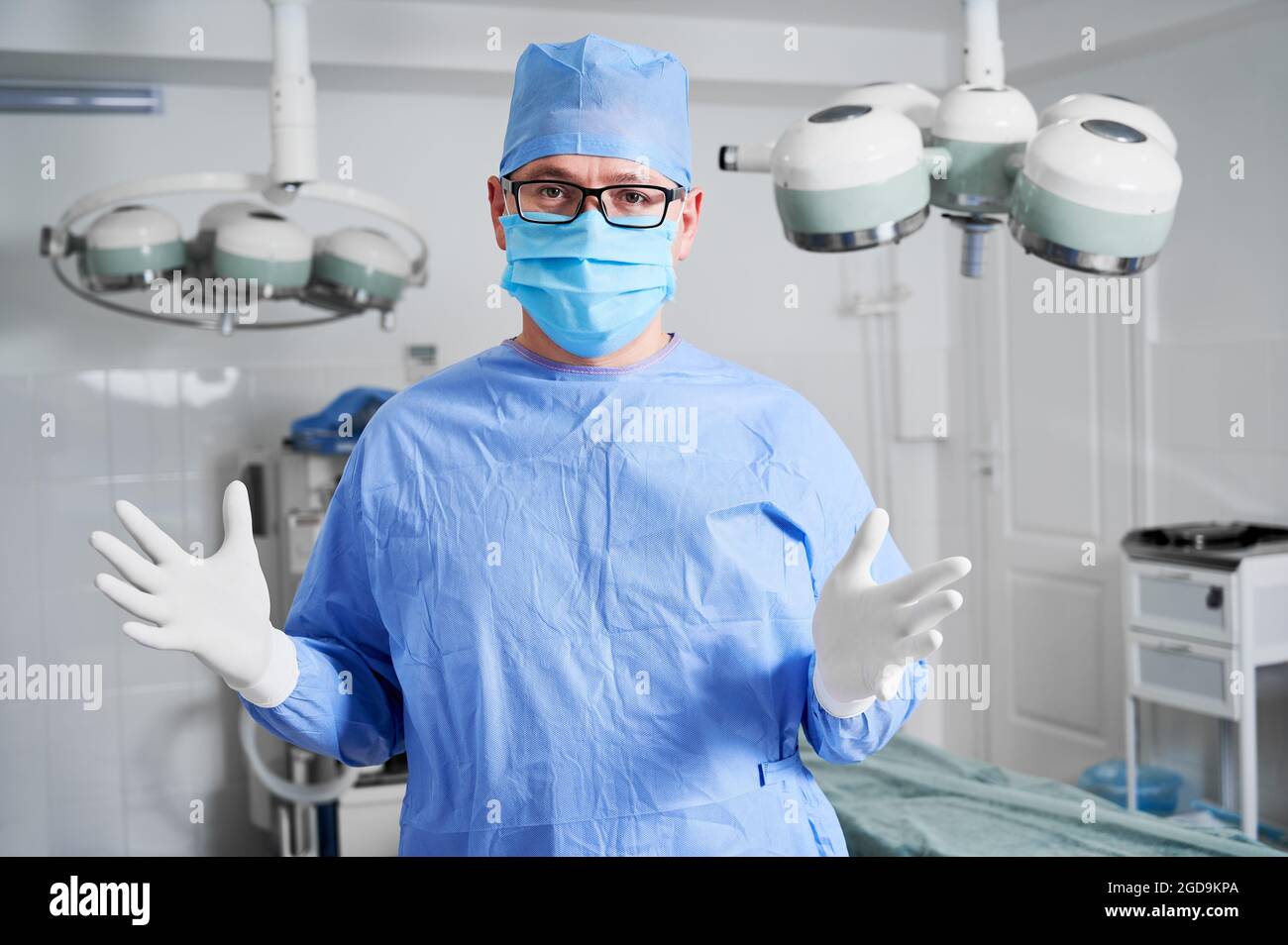 Portrait of doctor in glasses standing in operating room, ready for ...