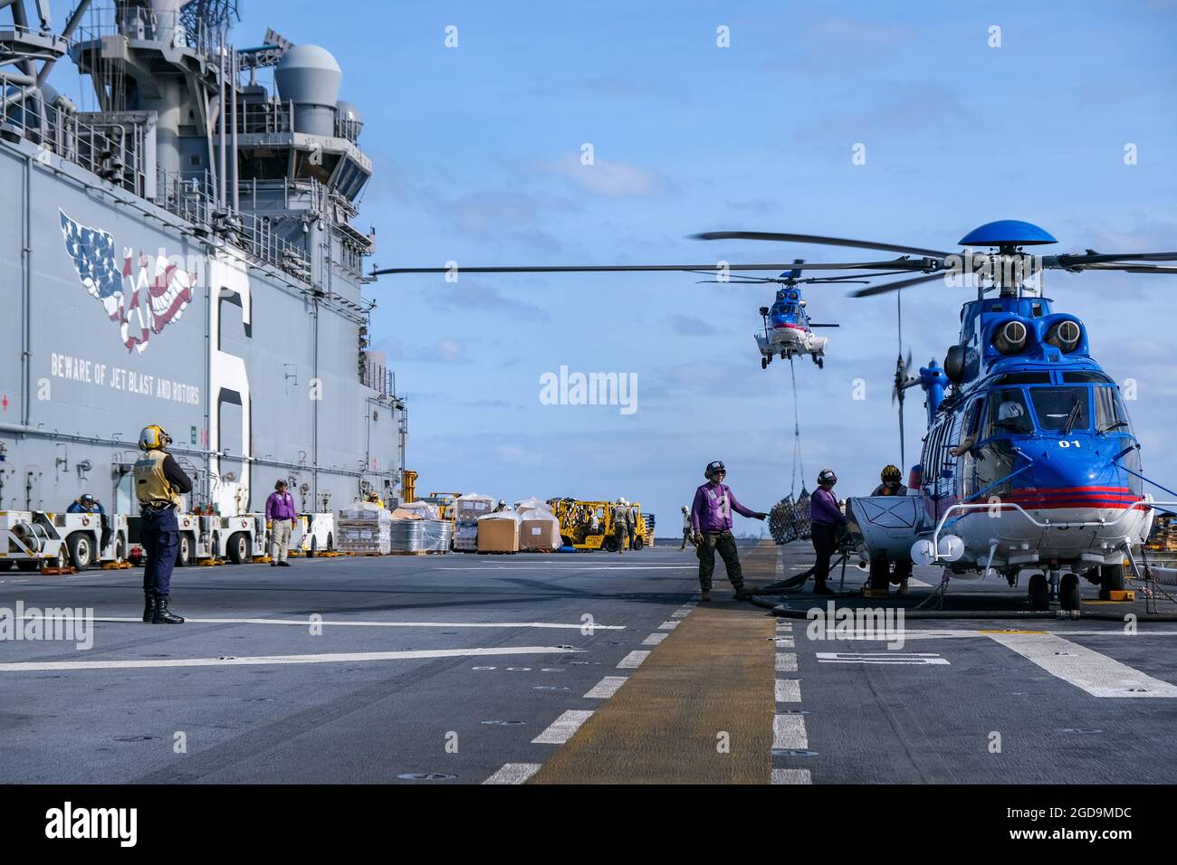 A U.S. Navy aviation boatswain’s mate fuels an Erickson EC-225LP aboard ...