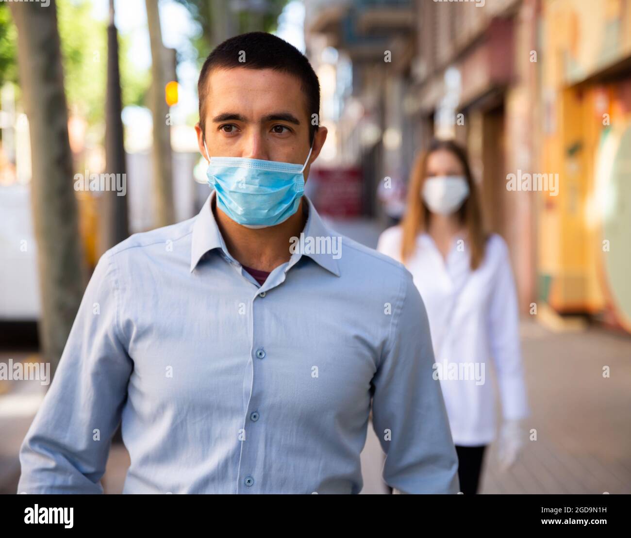 Man in disposable face mask walking on street Stock Photo - Alamy