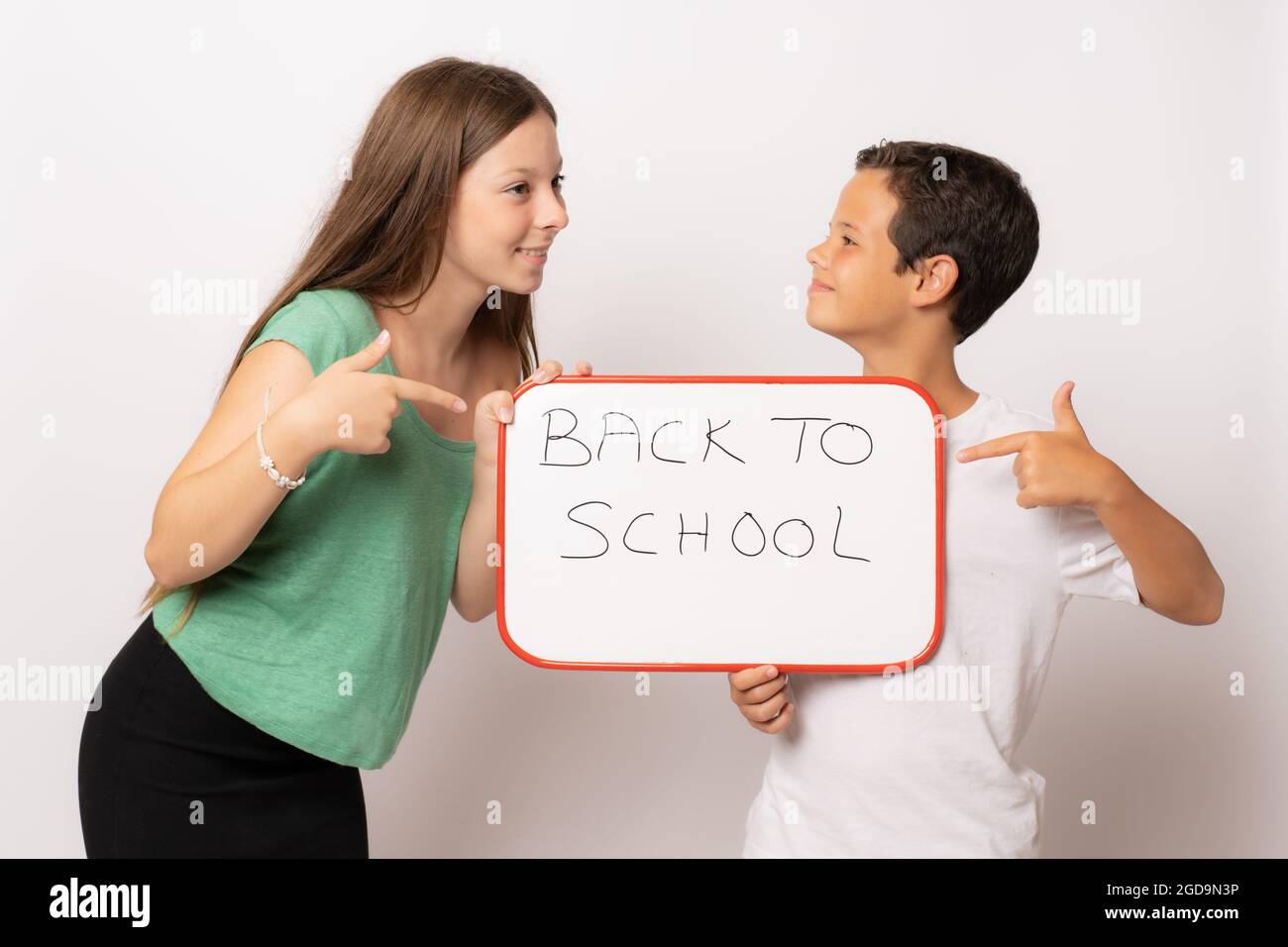 Two happy smiling students showing signboard. Back to school concept ...