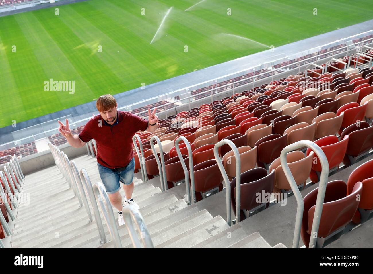 Portrait of man climbing stairs of football stadium Stock Photo - Alamy