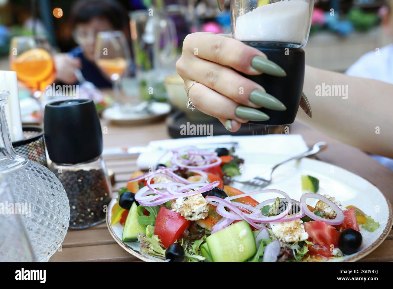 Woman adding salt to food in restaurant hi-res stock photography and ...