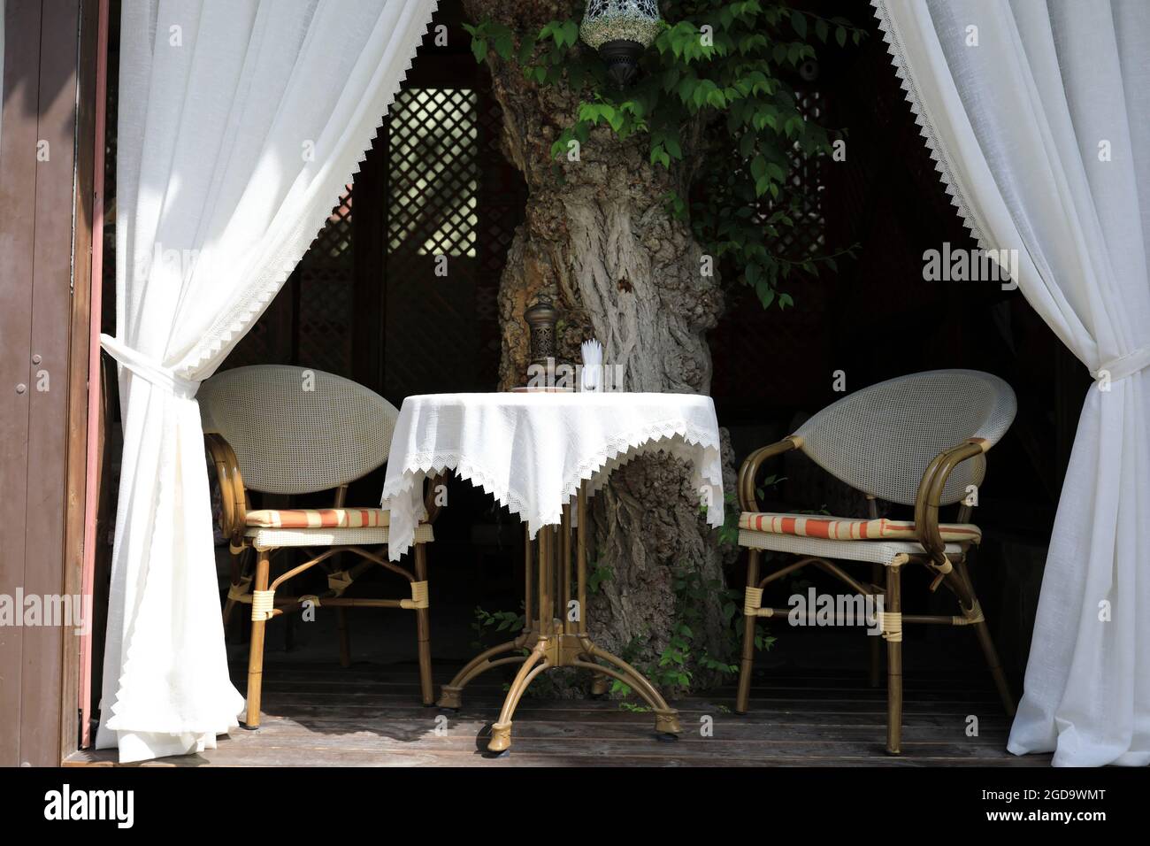 View of table with chairs on veranda of cafe Stock Photo - Alamy