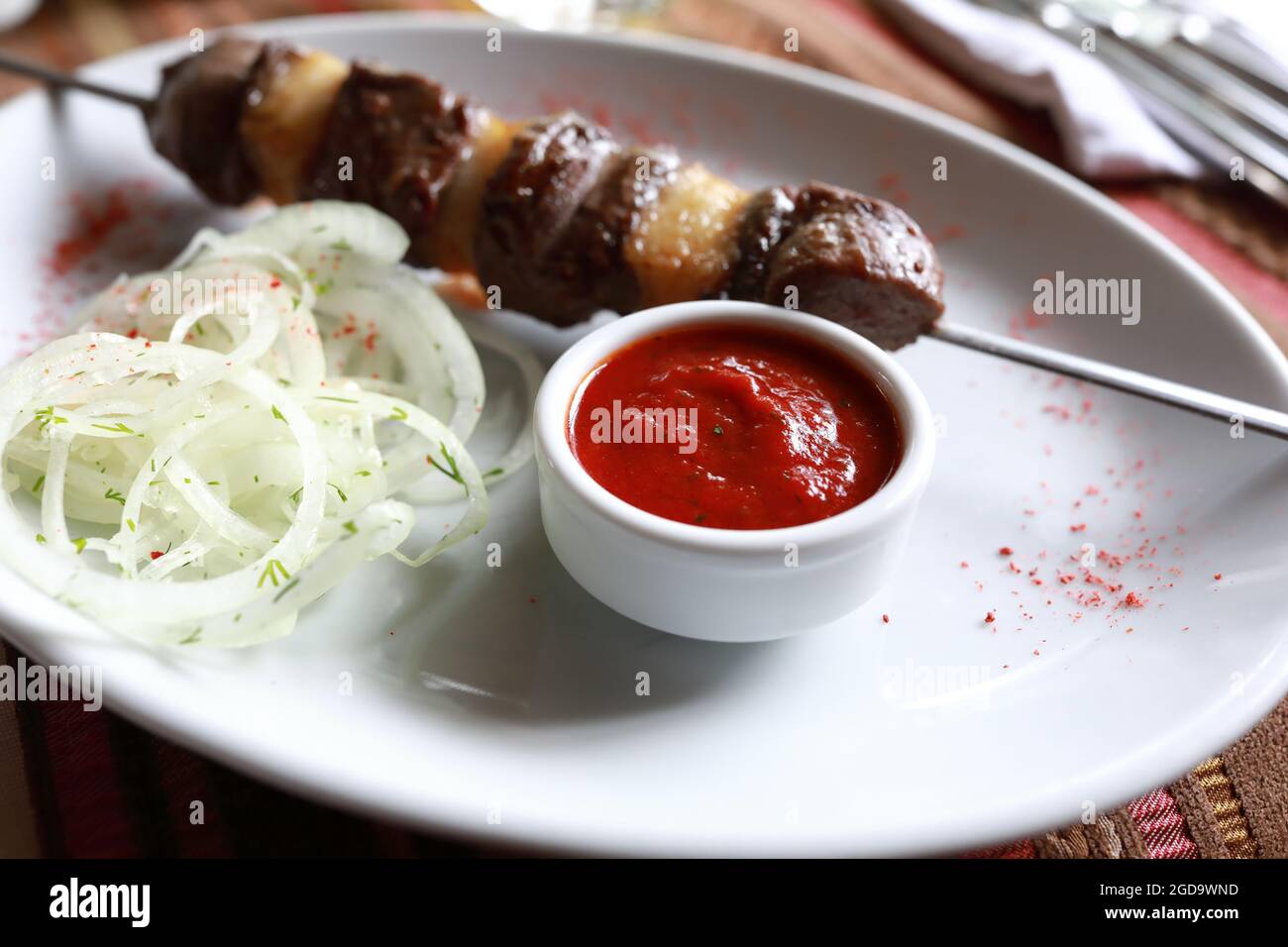 Lamb kebab with fat tail on skewer and sauce in restaurant Stock Photo ...