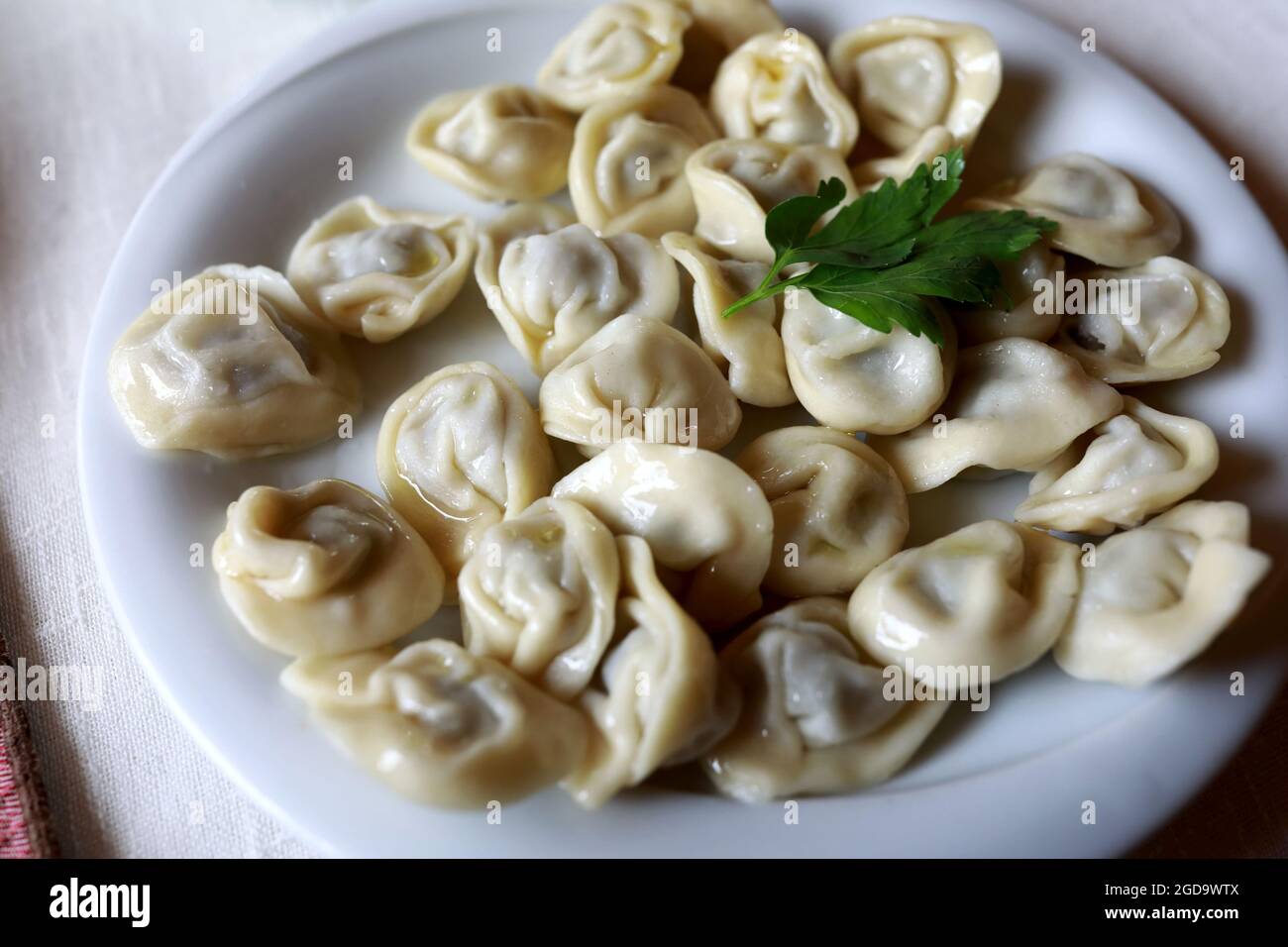 Dumplings on white plate with butter in restaurant Stock Photo - Alamy