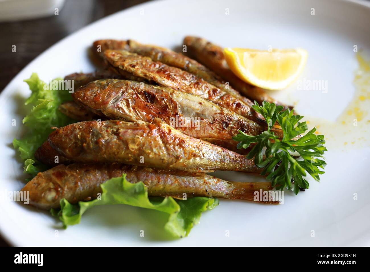 Fried red mullet with lemon in restaurant Stock Photo - Alamy