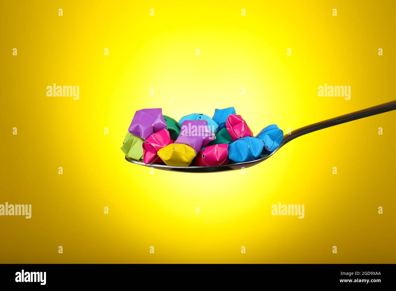 Paper stars in silver spoon on yellow background Stock Photo - Alamy