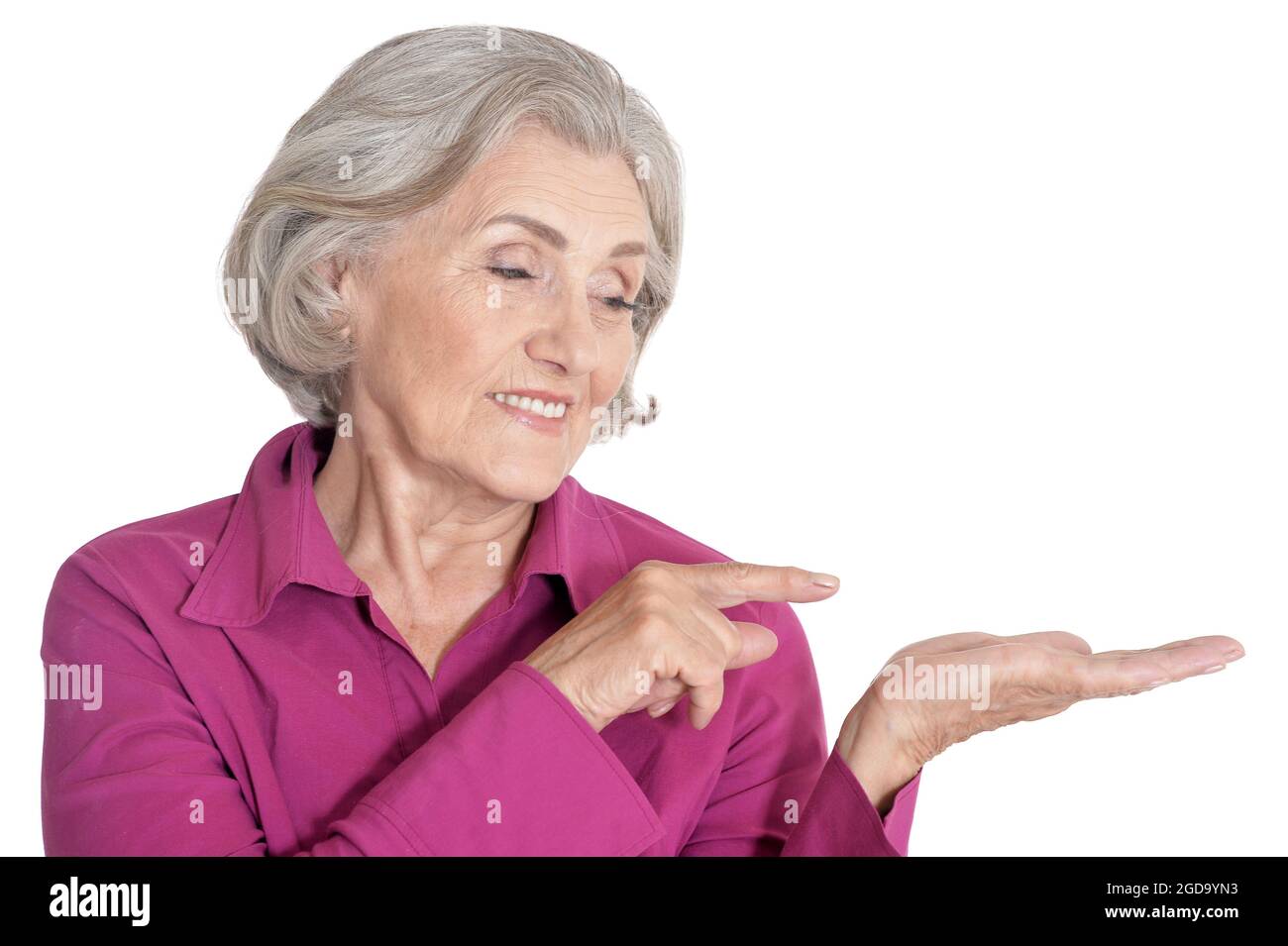 Smiling senior woman pointing at something on her palm Stock Photo - Alamy