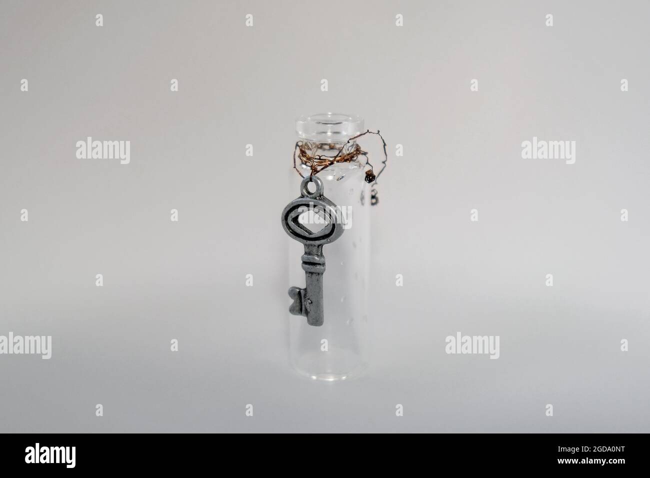 Small glass jar with an attached key Stock Photo - Alamy