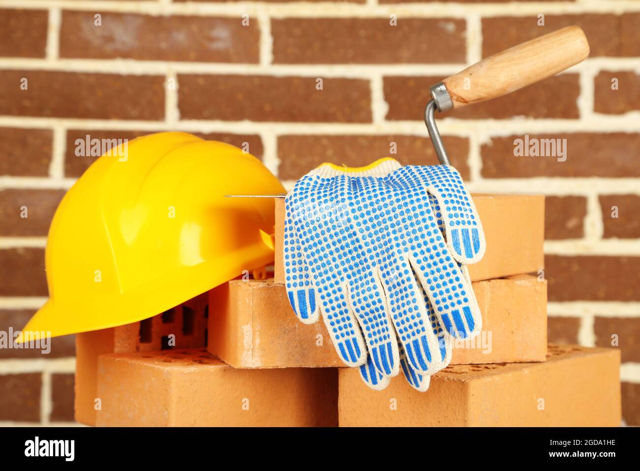 New bricks and building tools on brick wall background Stock Photo - Alamy