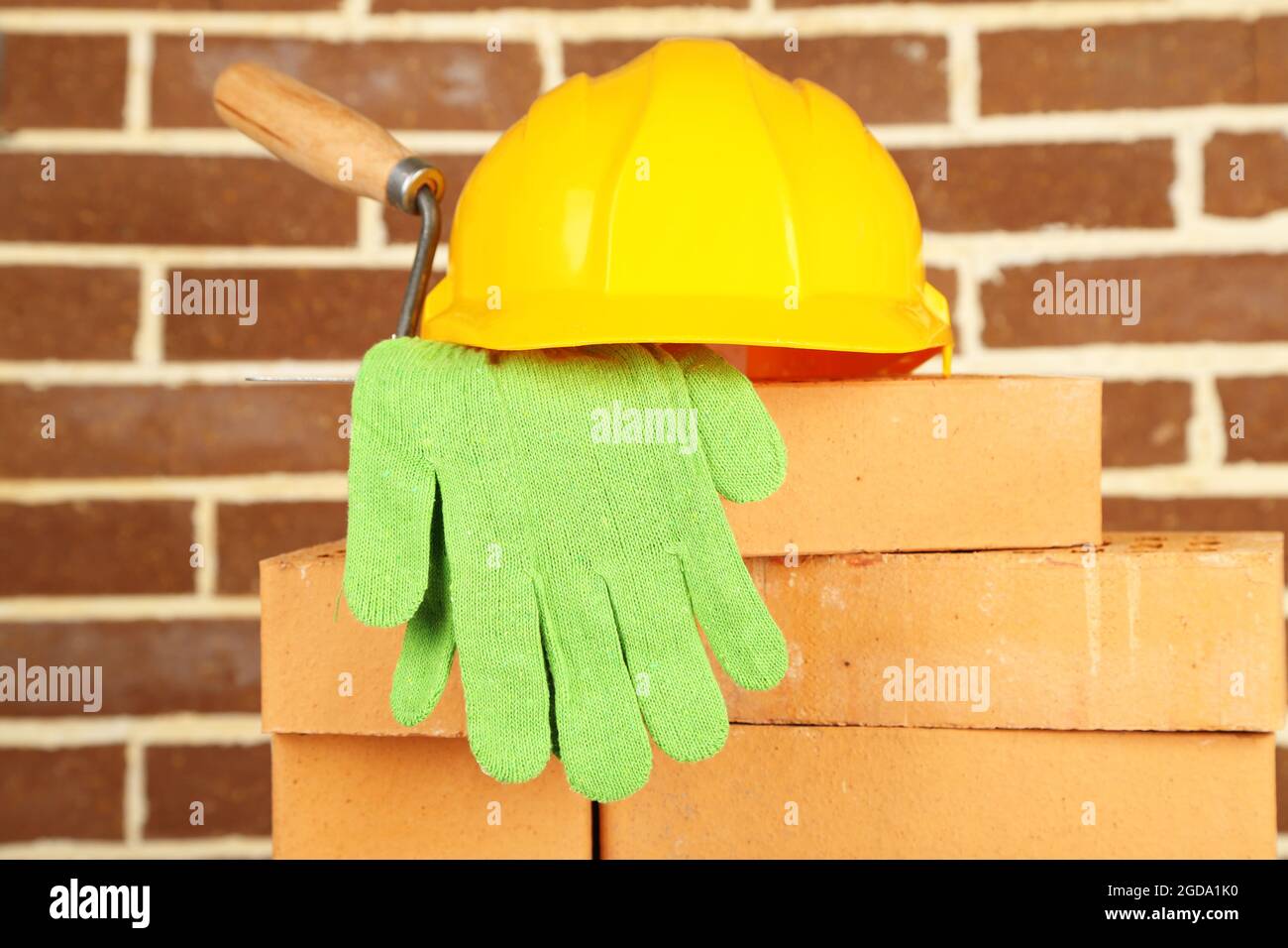 New bricks and building tools on brick wall background Stock Photo - Alamy