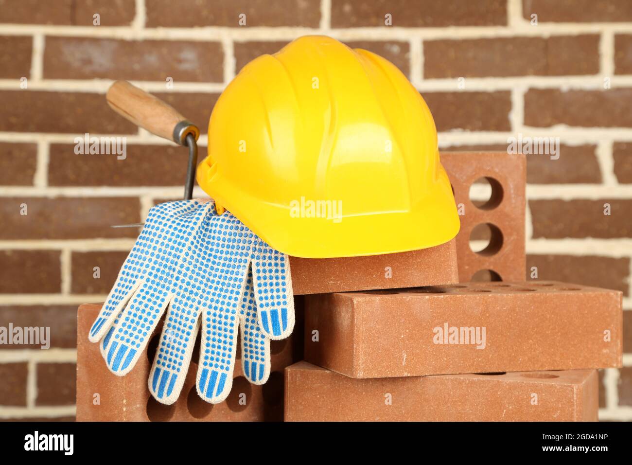 New bricks and building tools on brick wall background Stock Photo - Alamy