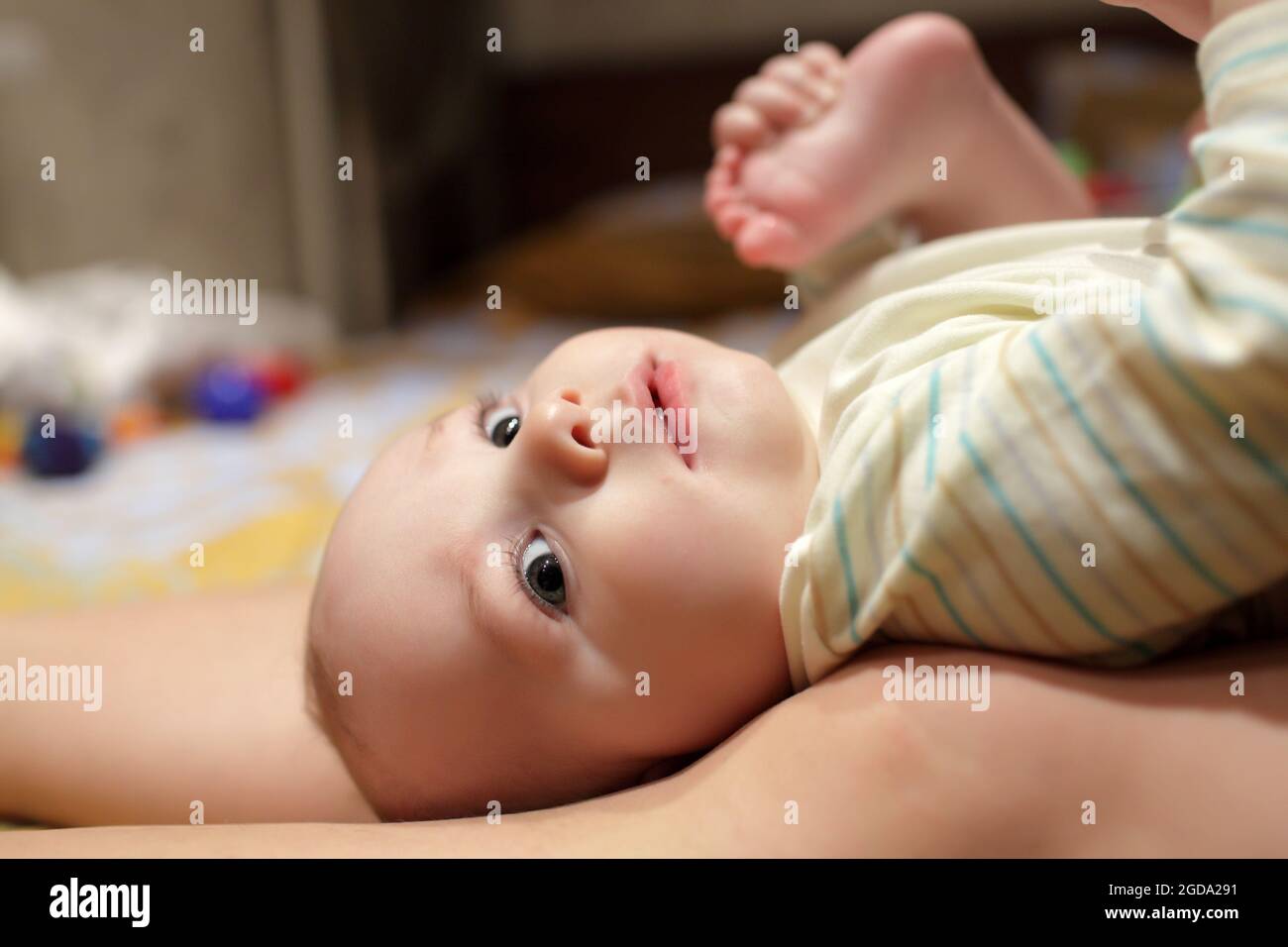 The baby lying on a mother's legs Stock Photo - Alamy