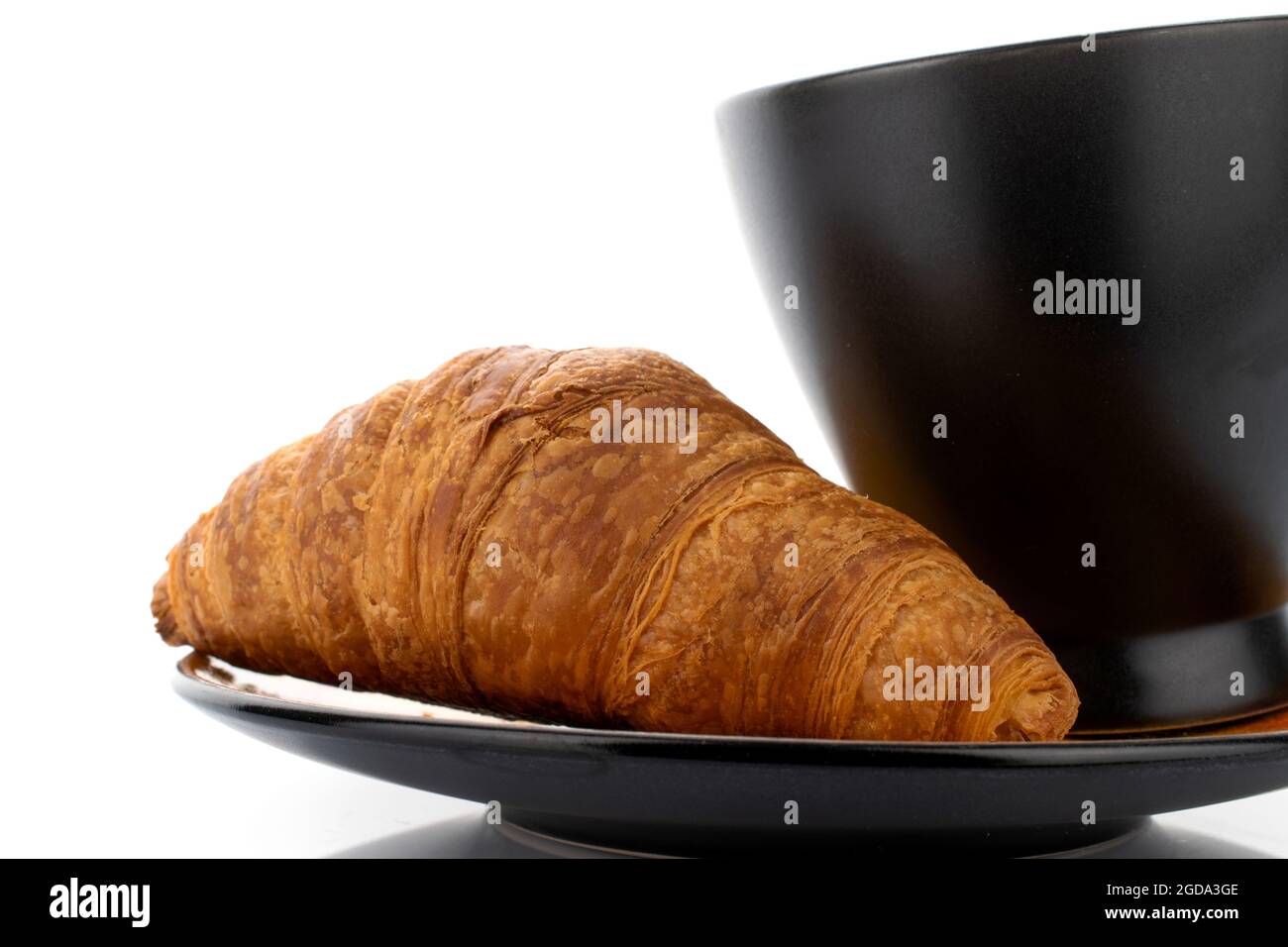 Appetizing homemade croissant on a saucer with a cup, close-up ...