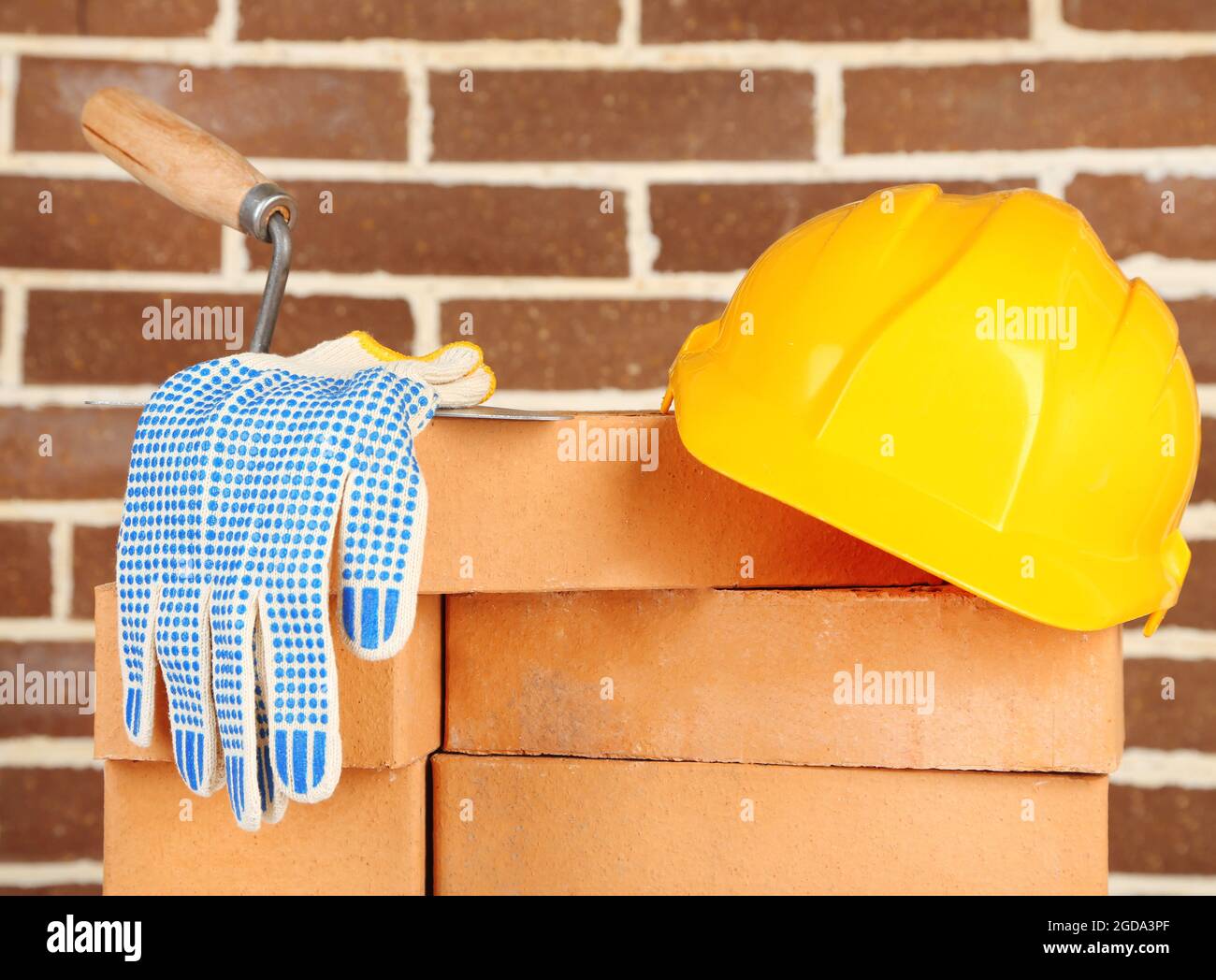New bricks and building tools on brick wall background Stock Photo - Alamy