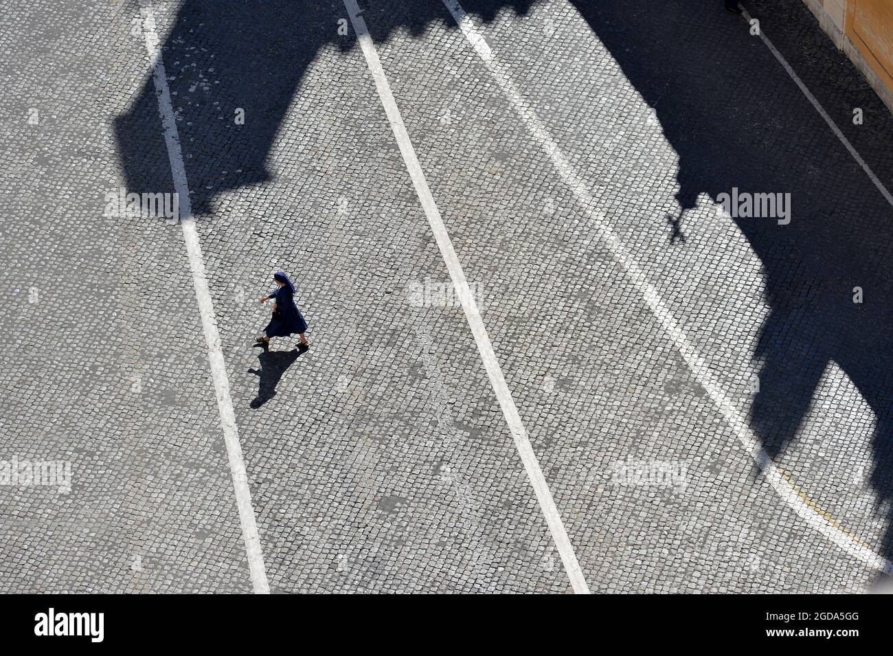 Nun crossing the courtyard of the Vatican City St.Peters Church ...