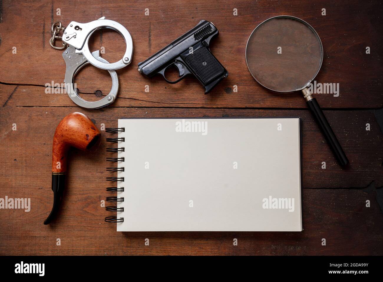 Crime investigation and arrest concept. Pistol handcuffs and a blank ...