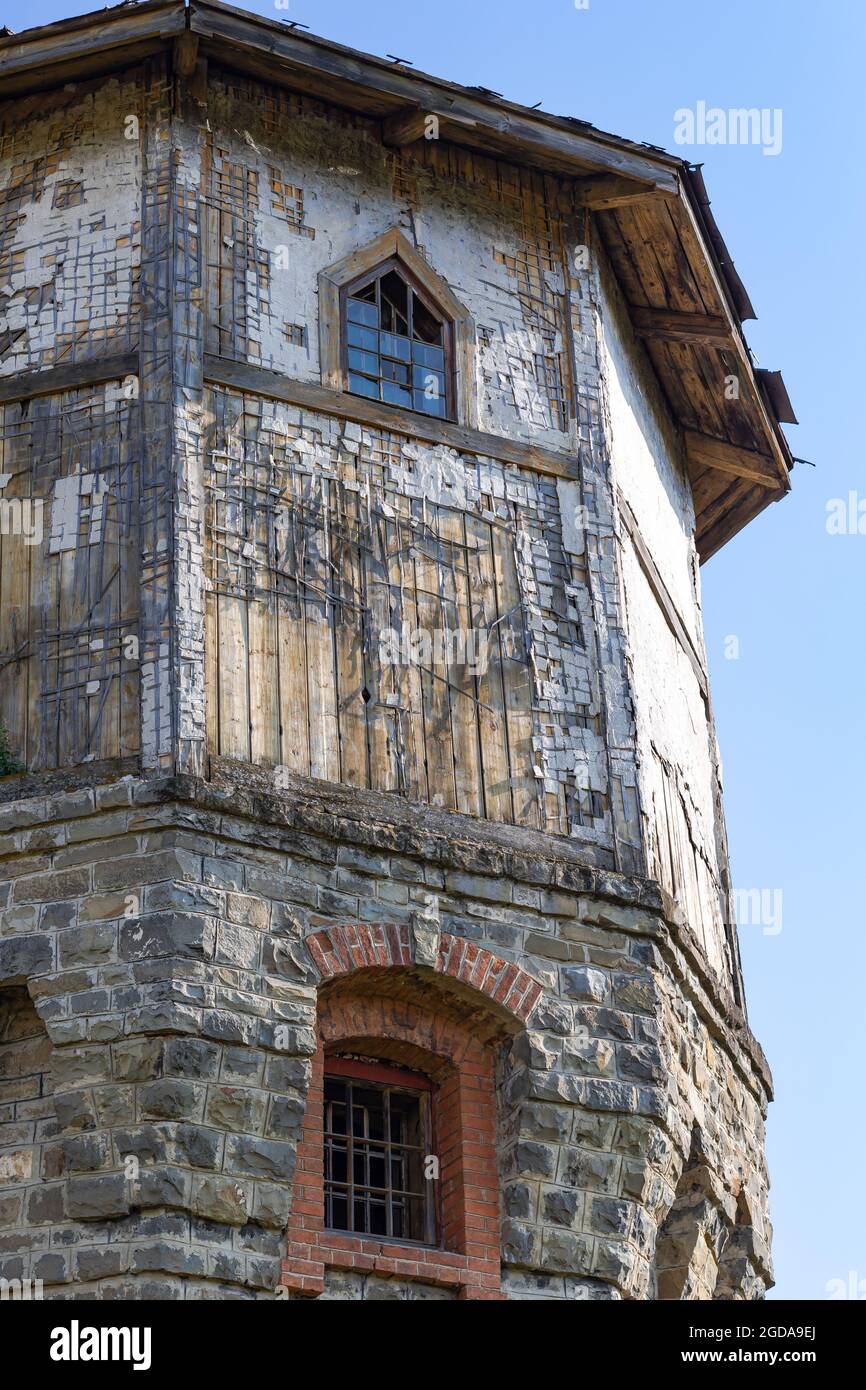 The upper part of an ancient watchtower made of stone blocks and wood ...