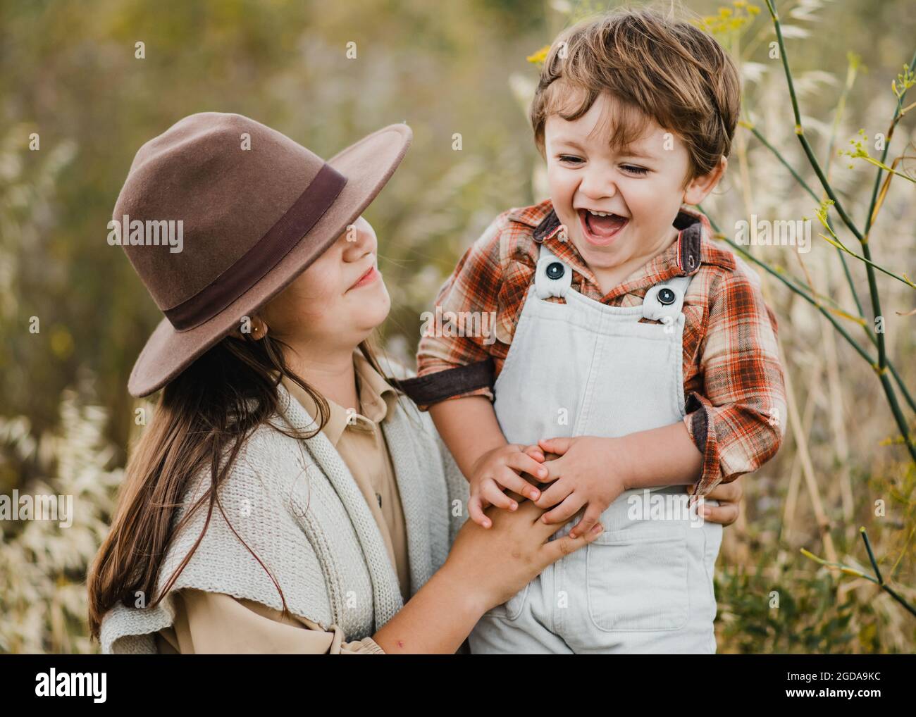 brothers play together and hug while smiling and having fun in country ...