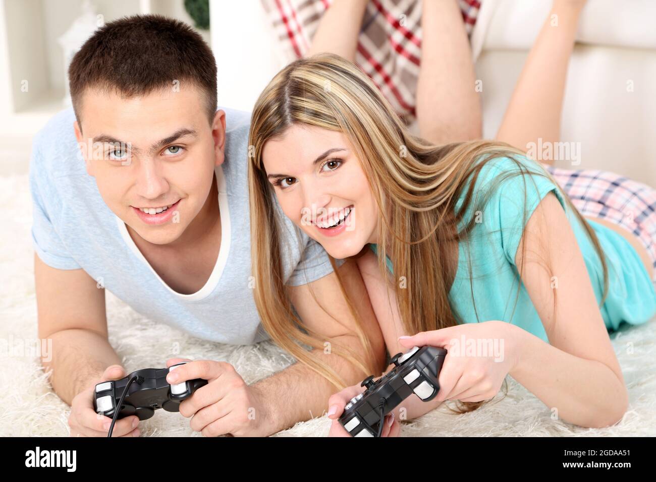 Couple playing video games on home interior background Stock Photo - Alamy