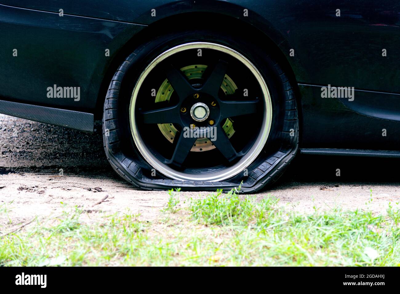 Punctured wheel of a modern car on the road. Car tire puncture Stock ...