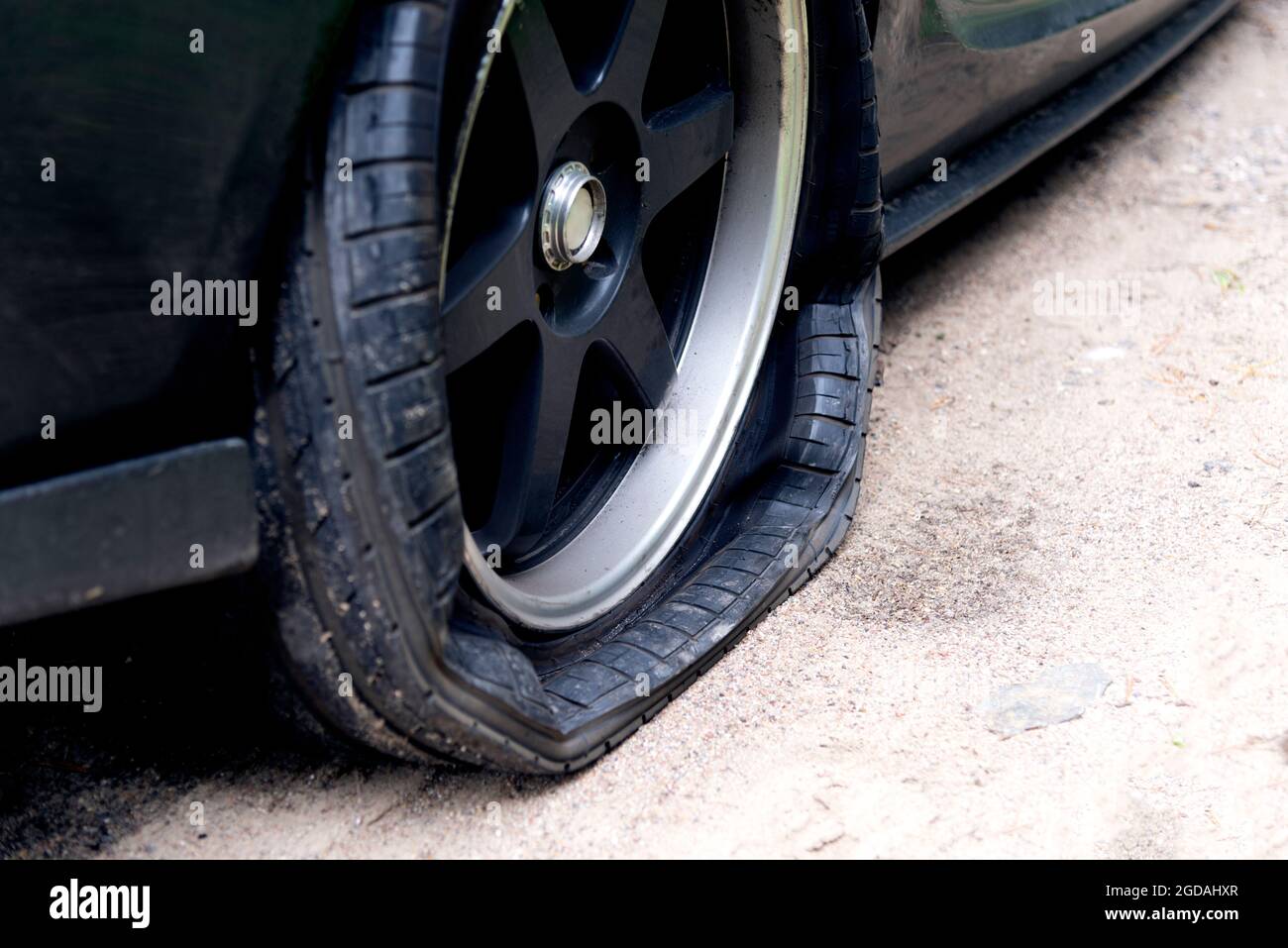 Punctured wheel of a modern car on the road. Car tire puncture Stock ...