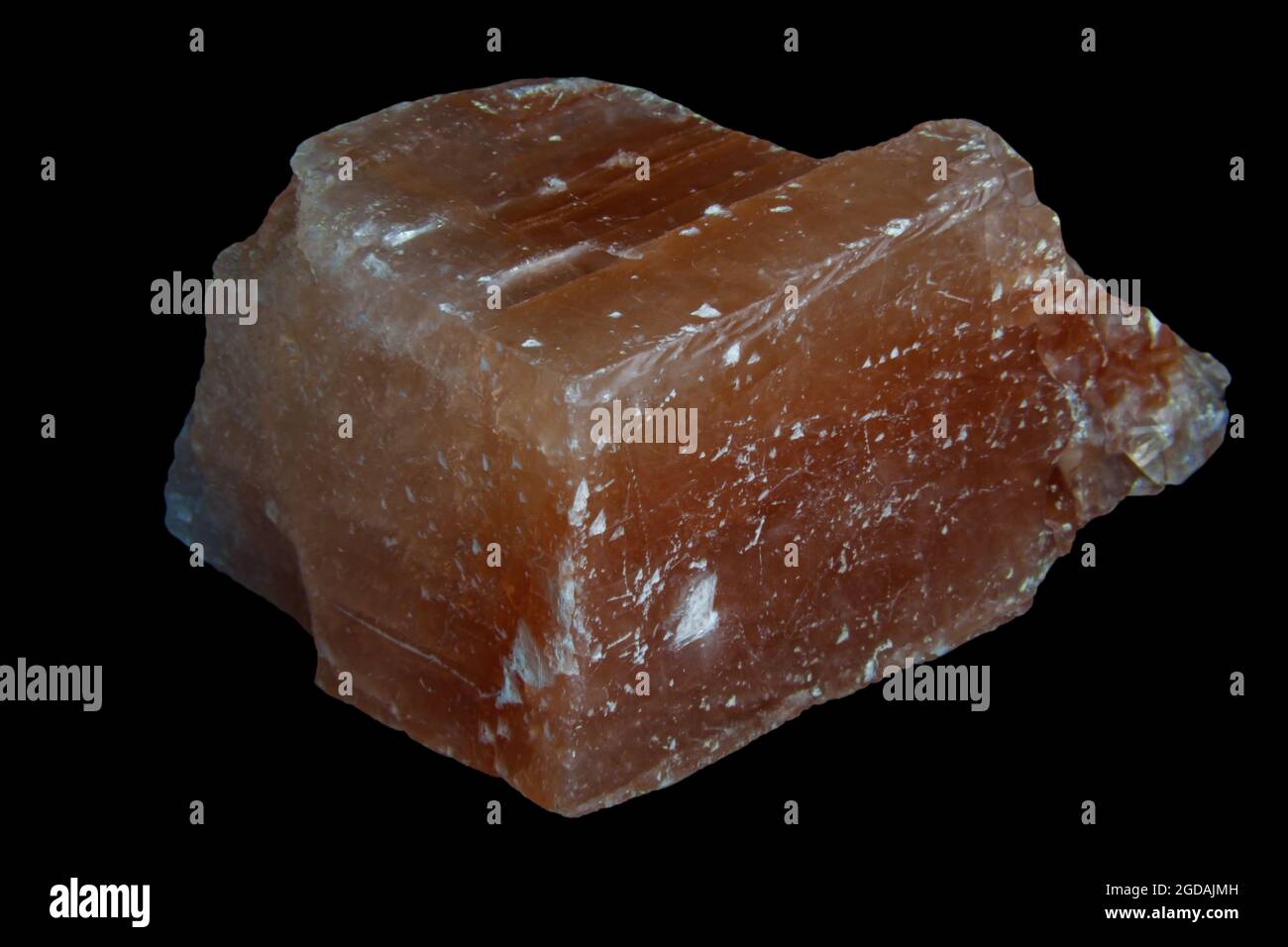 raw orange calcite cube isolated on a black background Stock Photo - Alamy