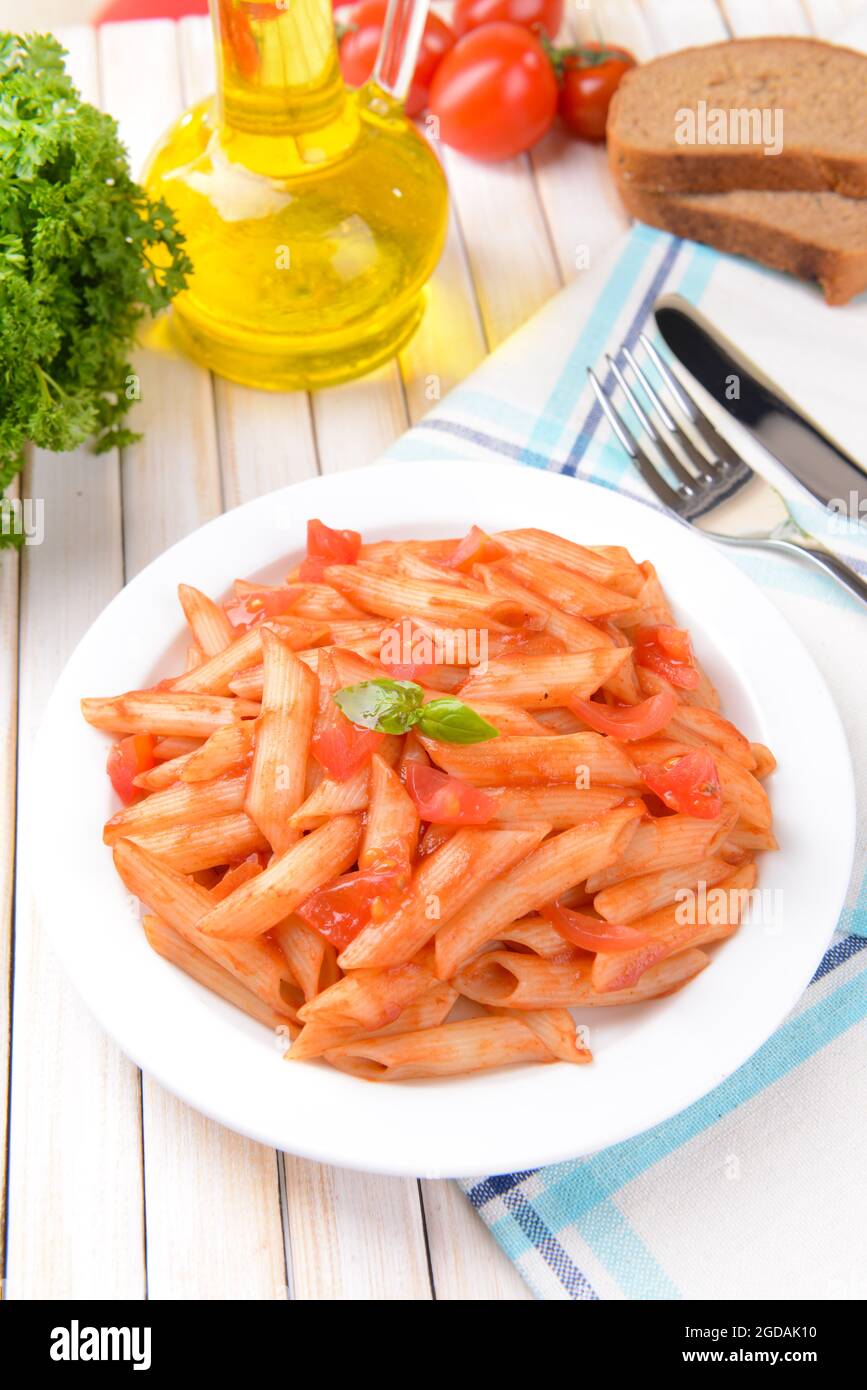 Pasta with tomato sauce on plate on table close-up Stock Photo - Alamy