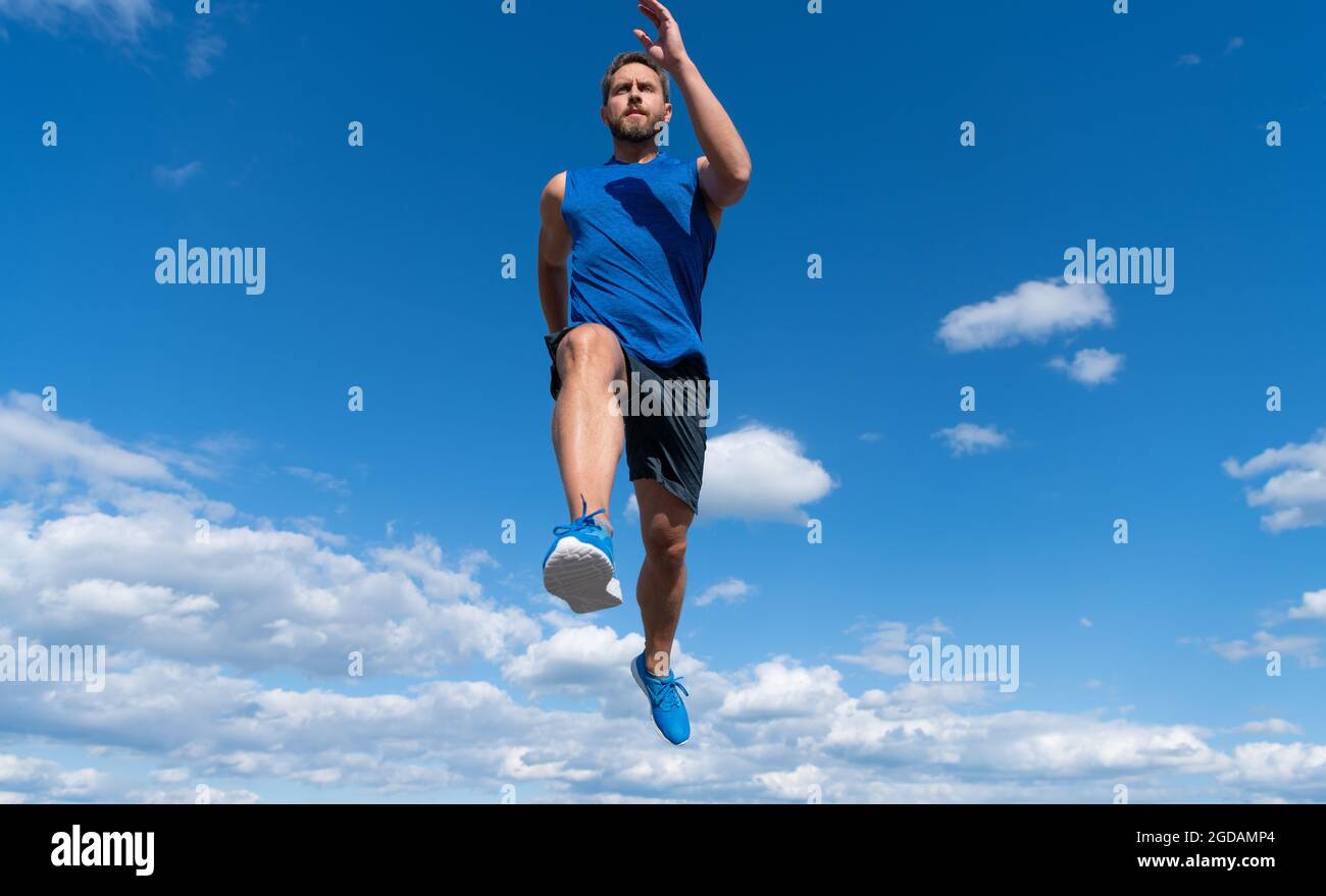 muscular man sprinter running in sportswear outdoor on sky background ...