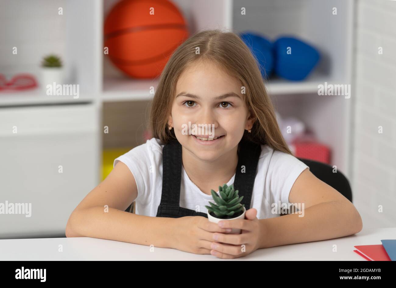 Girl holding plant in classroom hi-res stock photography and images - Alamy