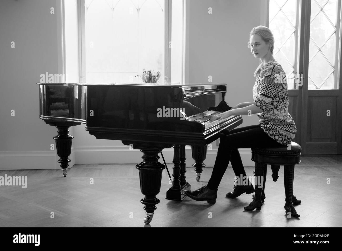 Pianist woman playing forte-piano in front the window at the castle ...