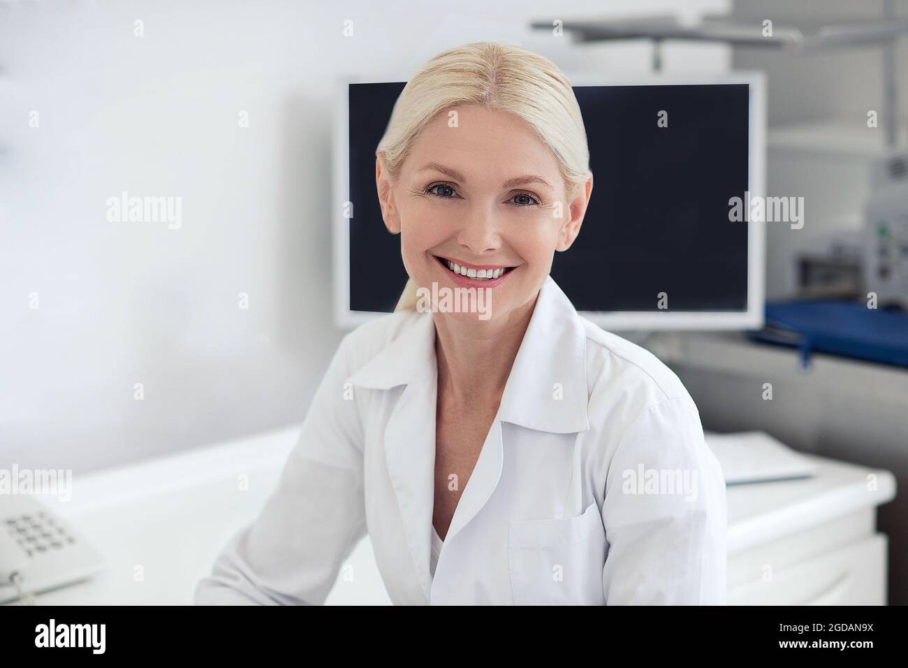 A good-looking female doctor smiling nicely Stock Photo - Alamy