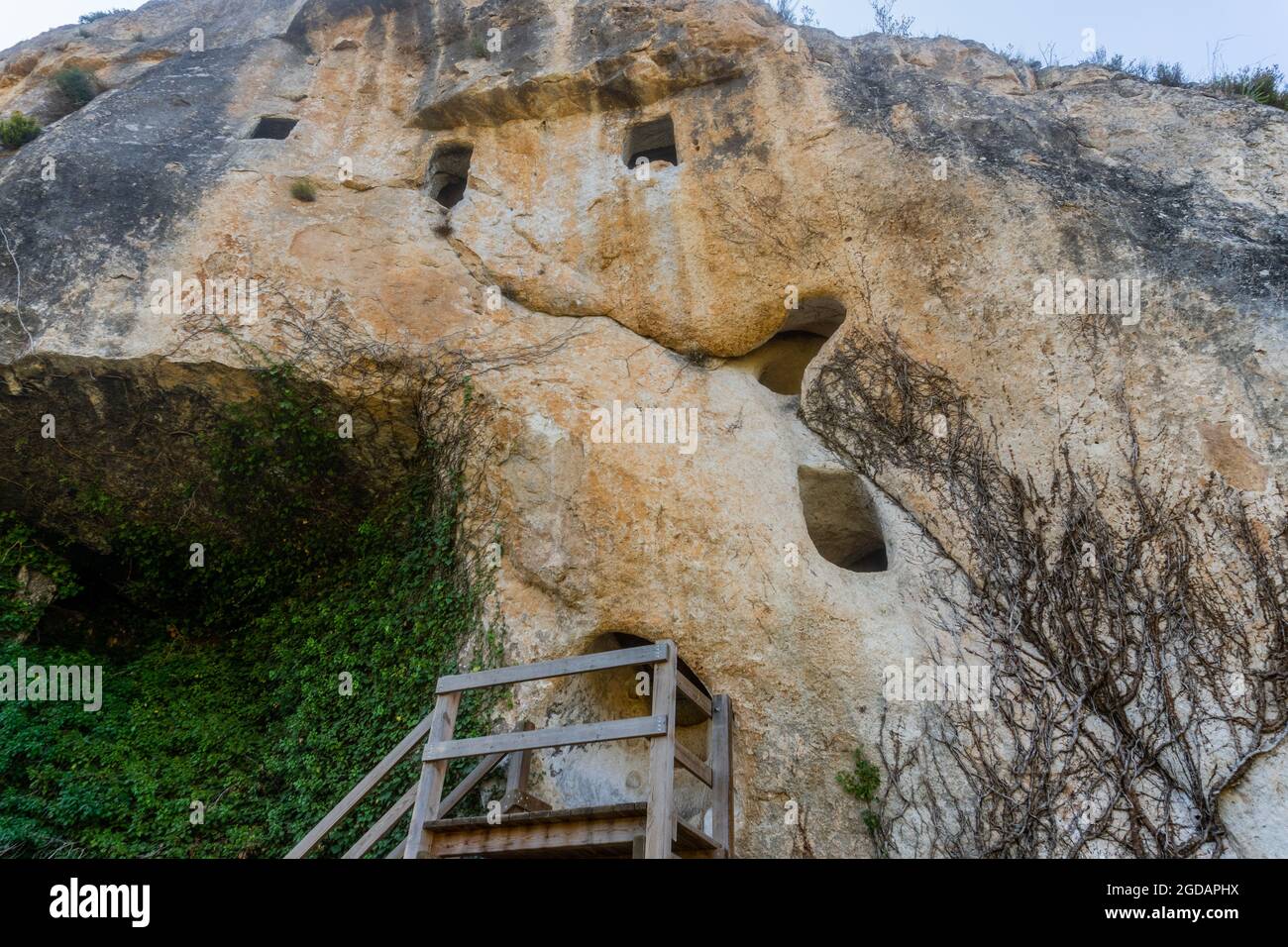 Scenic view of a cliff full of old caves Stock Photo - Alamy
