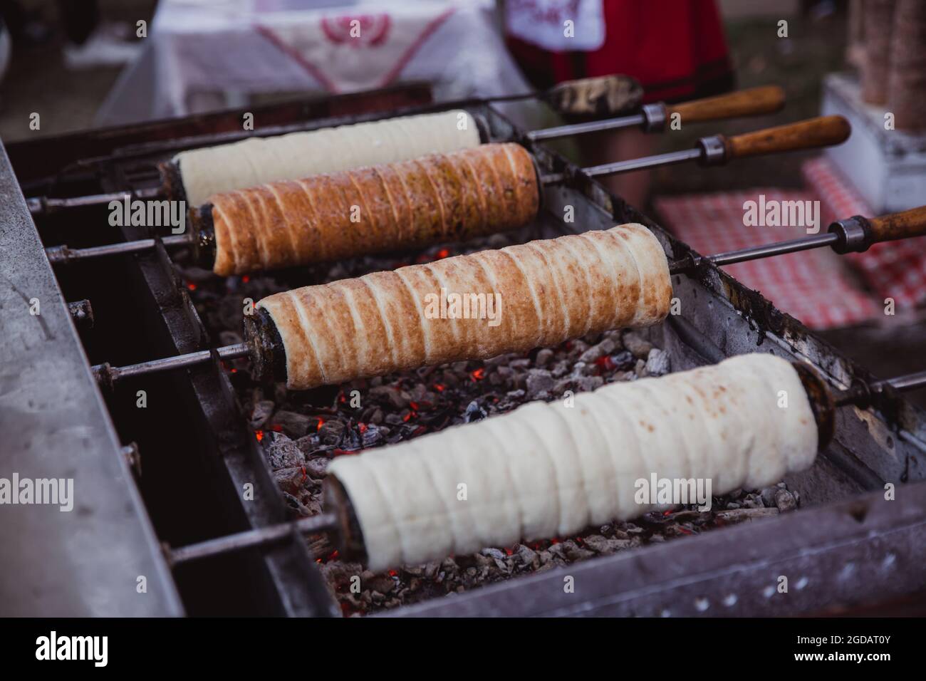 The baking of Kurtoskalacs, the traditional hungarian spit cake, in a ...
