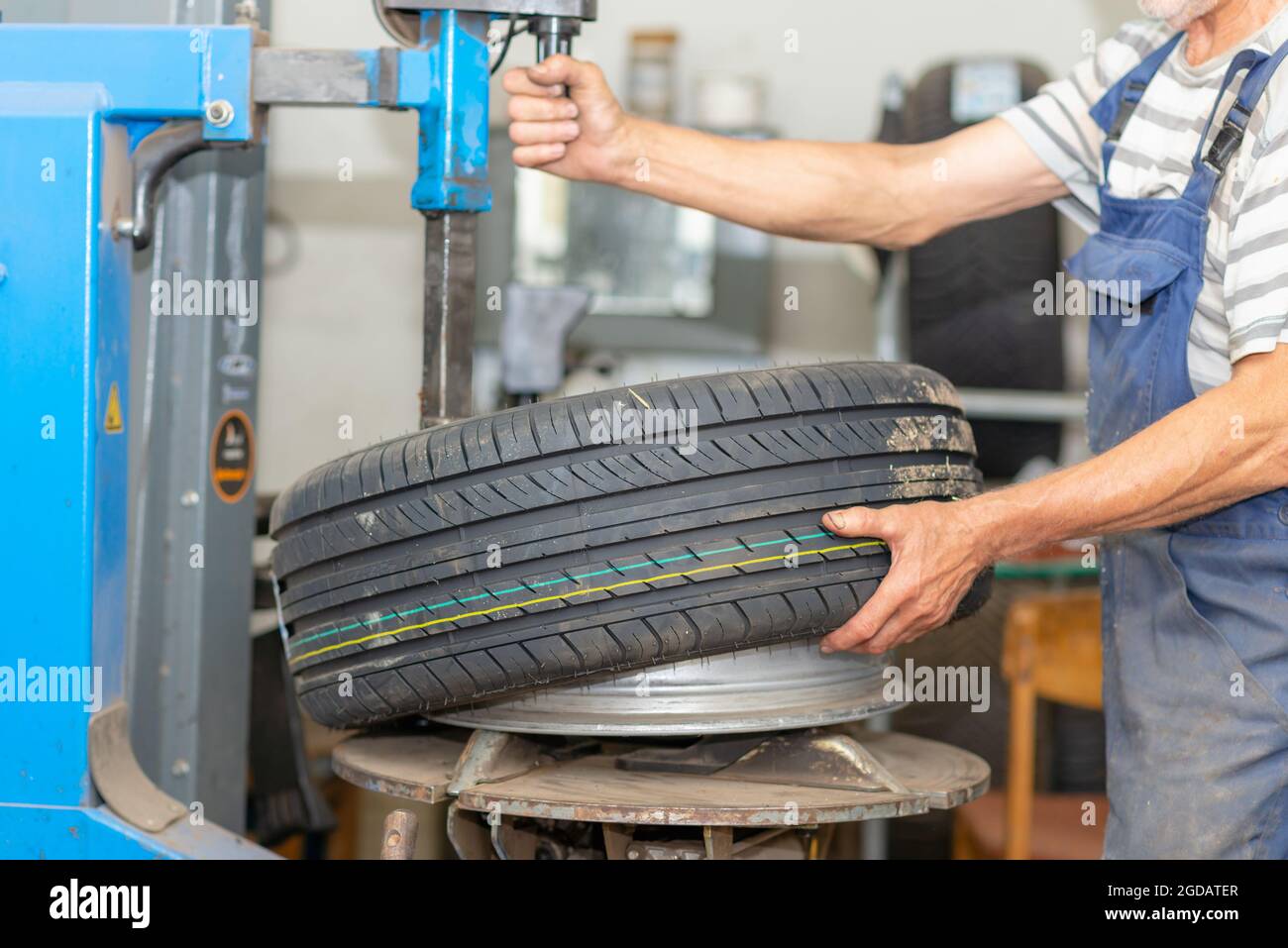 Mechanic changing tire in car service. Tire rotation machine.Car ...