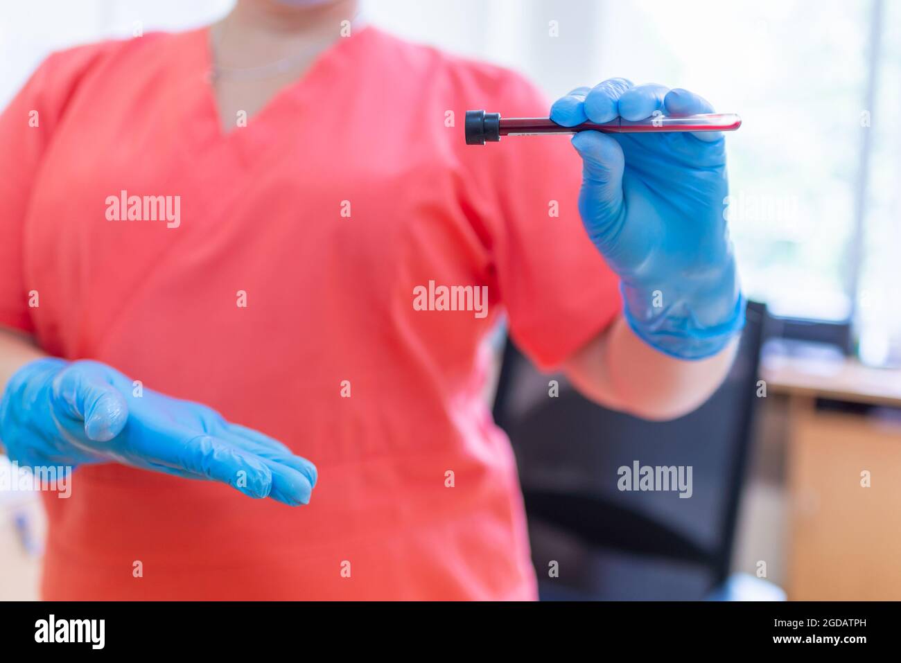 Female nurse holds test tube with a blood sample with positive test ...
