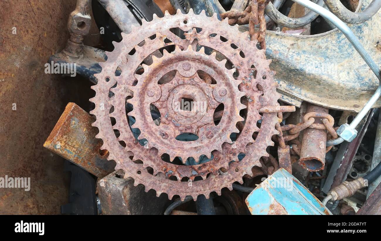 A shot of an old rusted bicycle gear drive lying amongst other ...